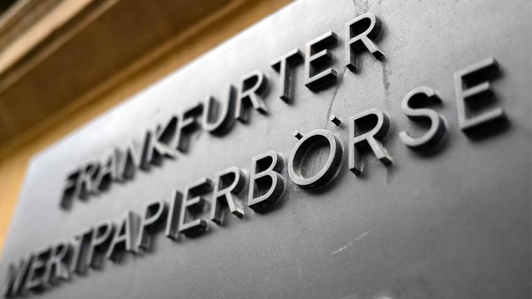 Eine Metallplatte mit der Aufschrift "Frankfurter Wertpapierbörse" an der Fassade vor der Frankfurter Börse.